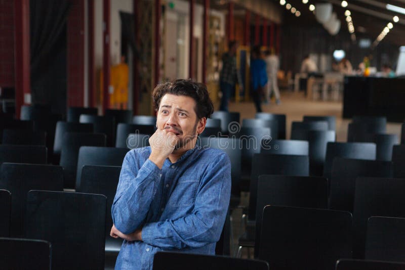 Scared Man Sitting in Conference Hall Stock Image - Image of hall, hand ...