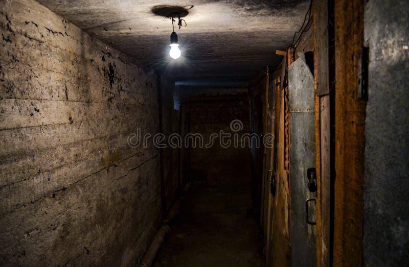 A Scary Dark Concrete Corridor in the Basement, Lit by a Single Light ...