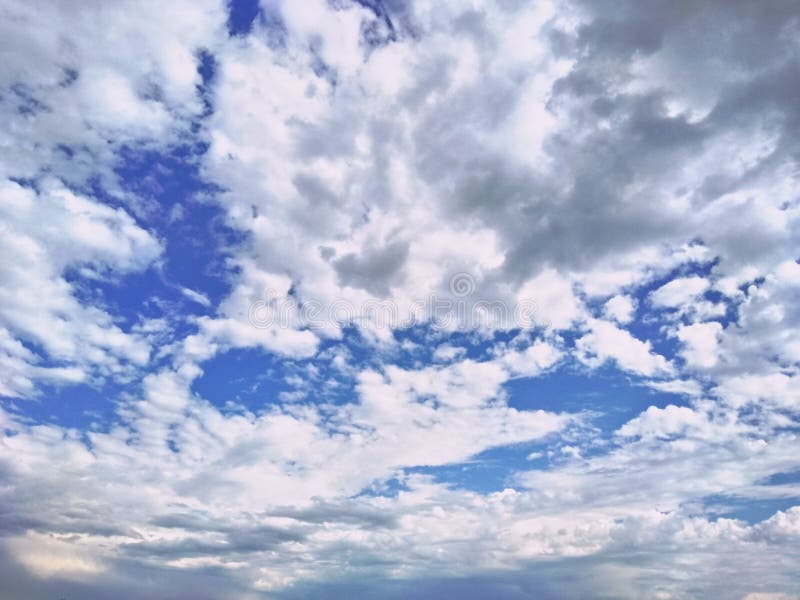 Scattered Grey Clouds Under a Bright Blue Sky Stock Photo - Image of ...