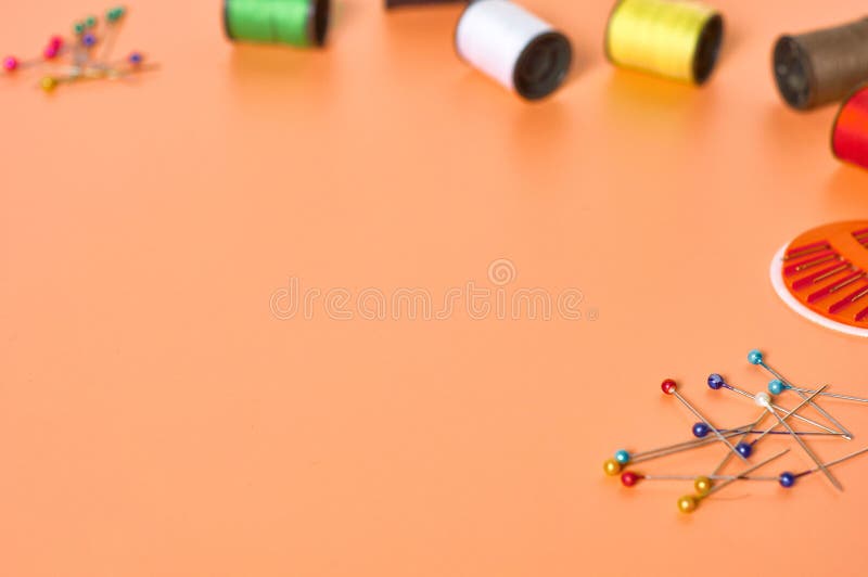 Scattered Needles and Spools with Colorful Threads on Orange Tailors ...