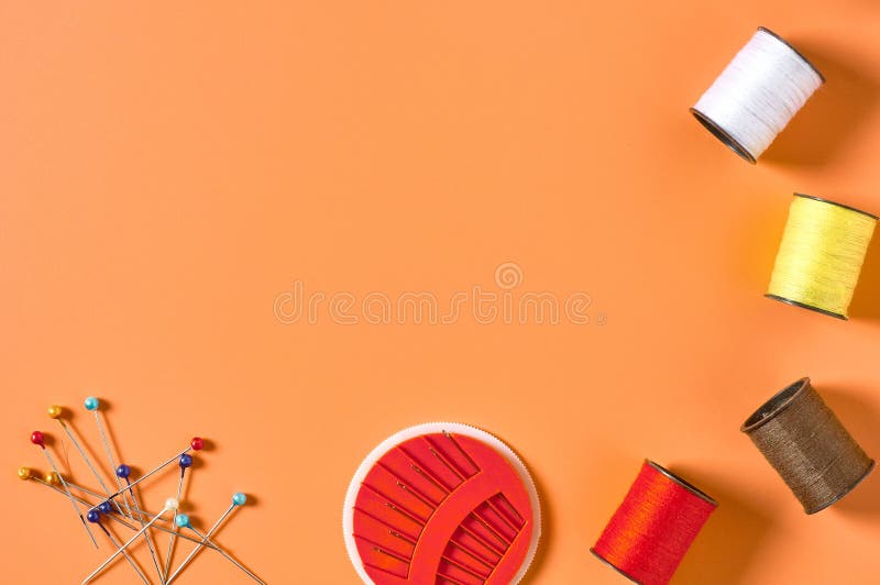 Scattered Needles and Spools with Colorful Threads on Orange Tailors ...