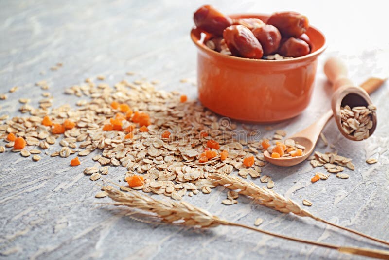 Scattered Oatmeal Flakes and Bowl with Dates on Table Stock Photo ...