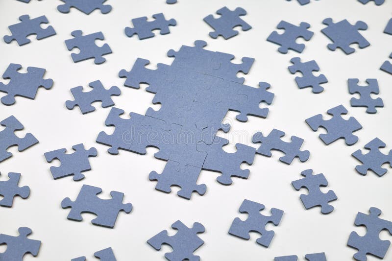 Scattered Puzzle Pieces Surround a Partially Assembled Section on a ...