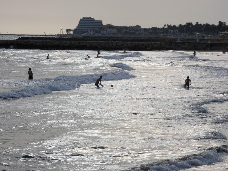 Scene of a Beach with Waves at the End of Summer, People Still Bathing ...