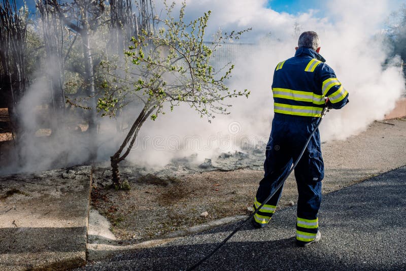 Scene of Extinguishing a Fire by a Professional Firefighter Using a ...