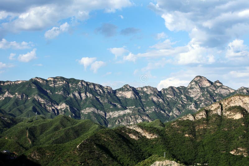 The Scenery of Rolling Mountains Under the Blue Sky and White Clouds ...