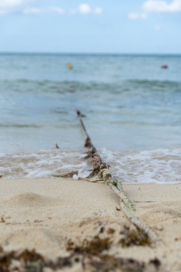 Scenery of a Rope at the Ocean Shore with the Waves Moving Towards the ...