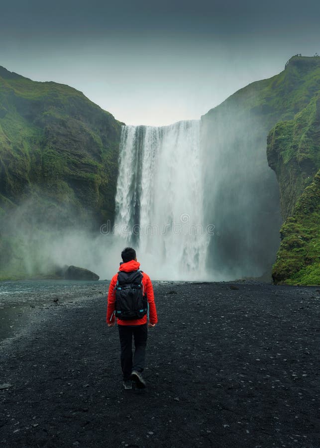 Scenery of Skogafoss Waterfall Flowing with Asian Man Backpacker ...