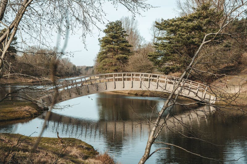 Scenic Autumn Landscape Featuring a Bridge Stretching Across a River ...