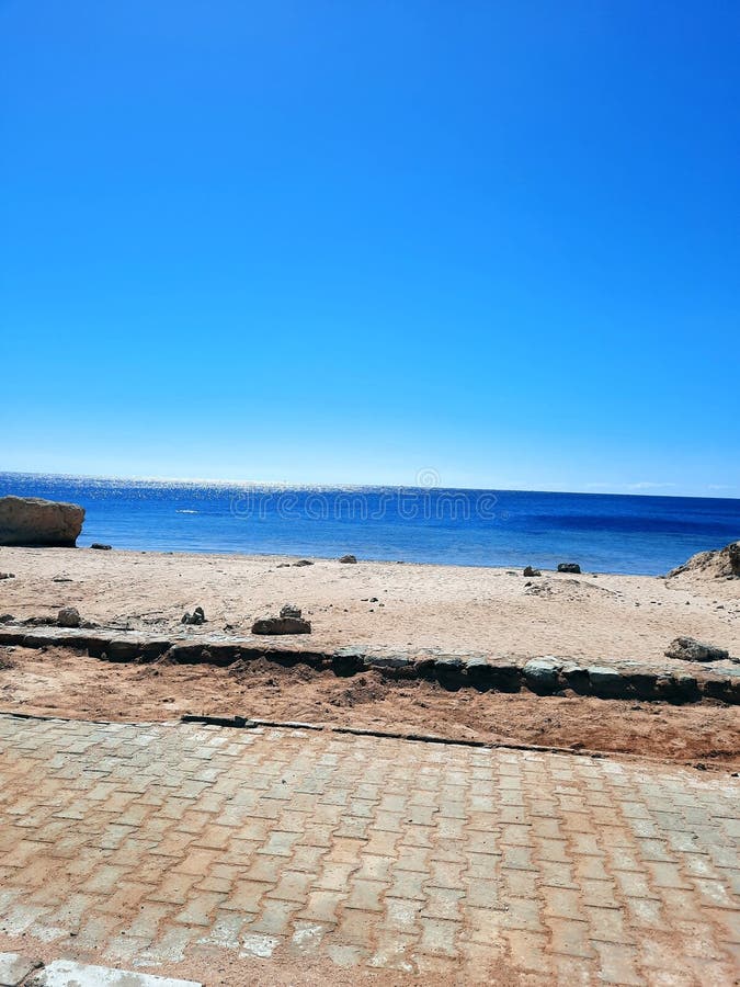 Scenic Beach with Paved Pathway and Clear Blue Sky on a Sunny Day Stock ...