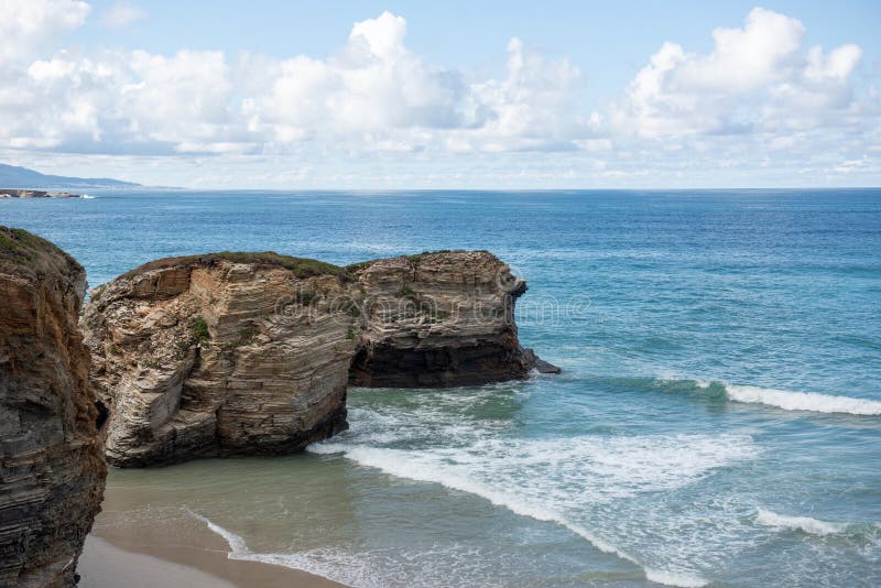 Scenic Coastal View Featuring Rugged Cliffs, Gentle Waves Lapping ...