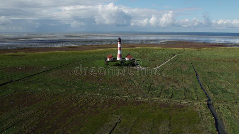Scenic Drone Footage of a Lighthouse in the Middle of a Large Field ...