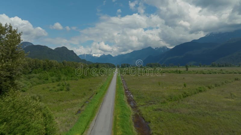 Scenic Drone View of a Roadway Winding through Lush Greenery Leading ...