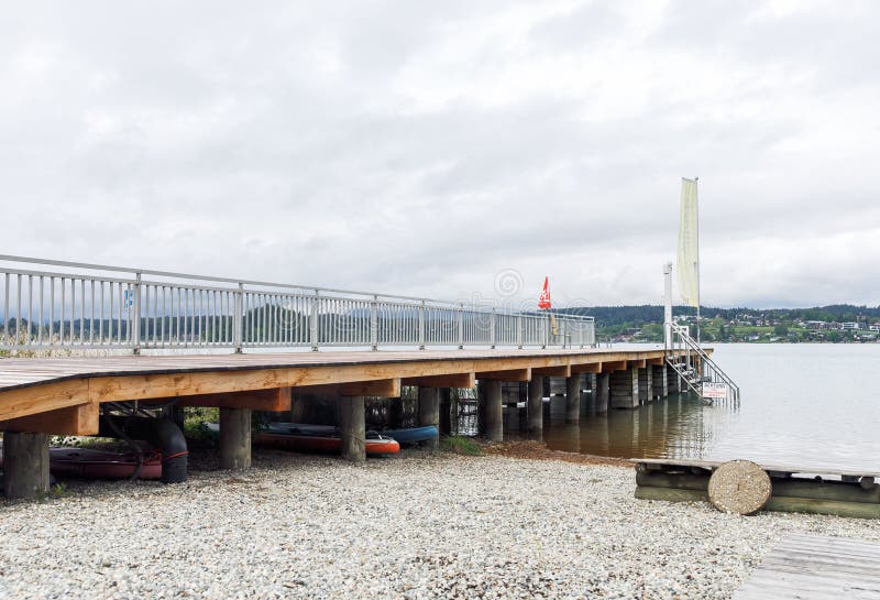 Scenic Lakeside Pier with Overcast Sky and Calm Waters Editorial ...