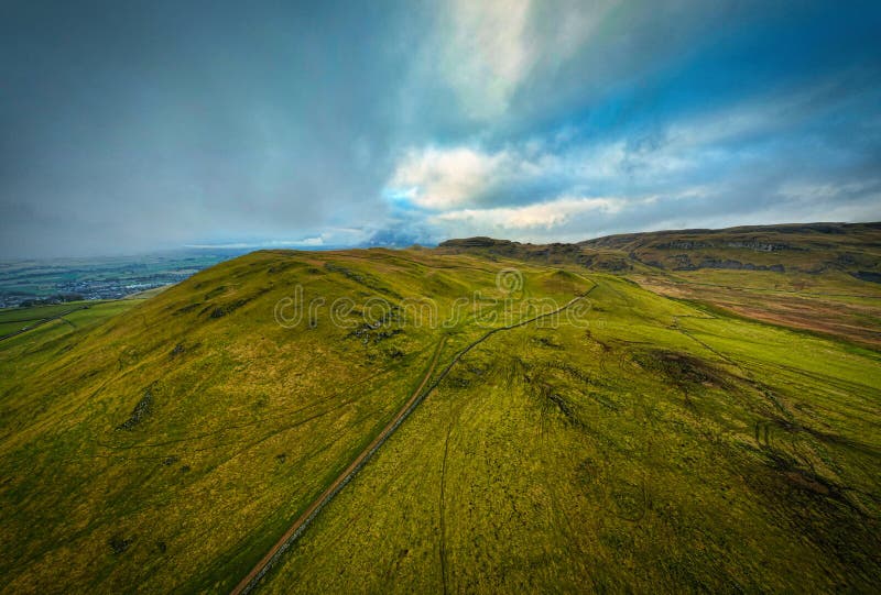 Scenic Landscape with Lush Green Fields Under a Dramatic Sky with ...