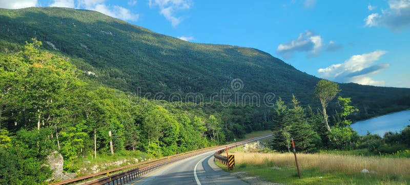 Scenic Shot of a Curved Road on the Base of a Mountain and Along a Lake ...