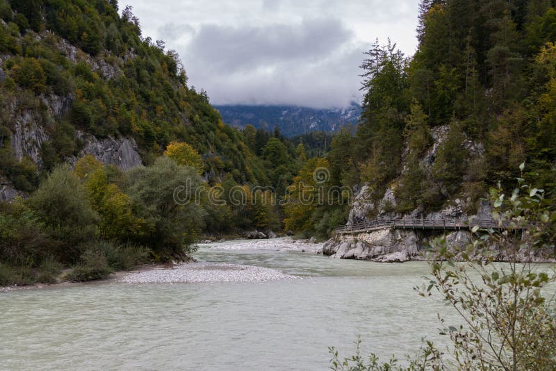 Scenic Shot of a River Flowing between High Mountains and Trees with a ...