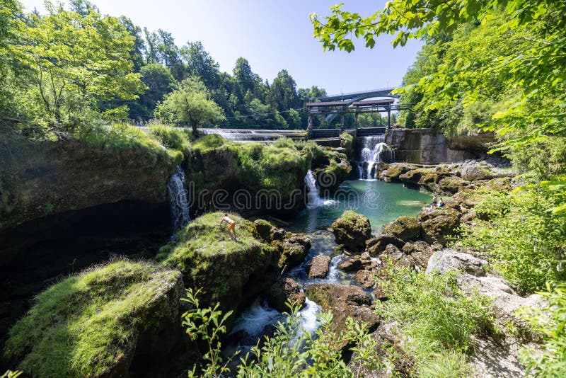 Scenic Shot of a Waterfall Surrounded by Flowing Water and Greenery ...