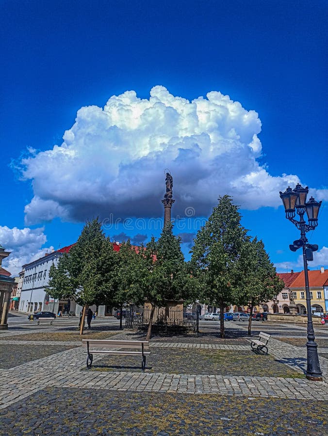 Scenic Urban Square with Monument, Benches, and Dramatic Cloudy Sky ...