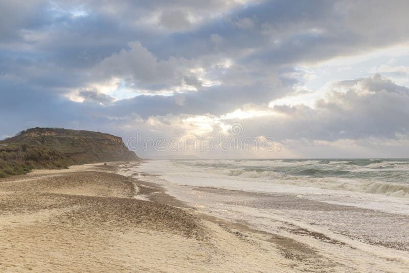 A Scenic View of a Beach Along Cliff with Huge Waves and Foam Under a ...