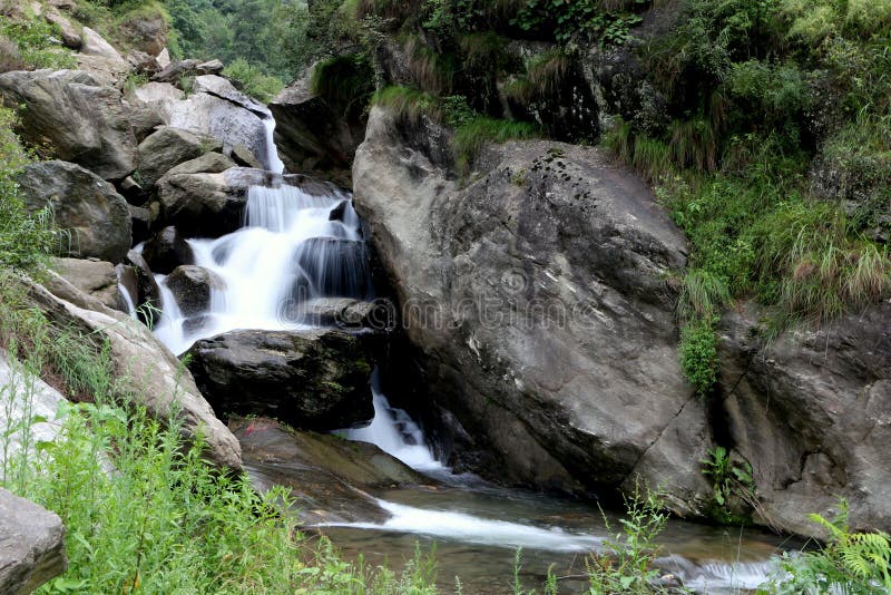Scenic View of a Cascade Flowing Down the Rocks Covered with Greenery ...