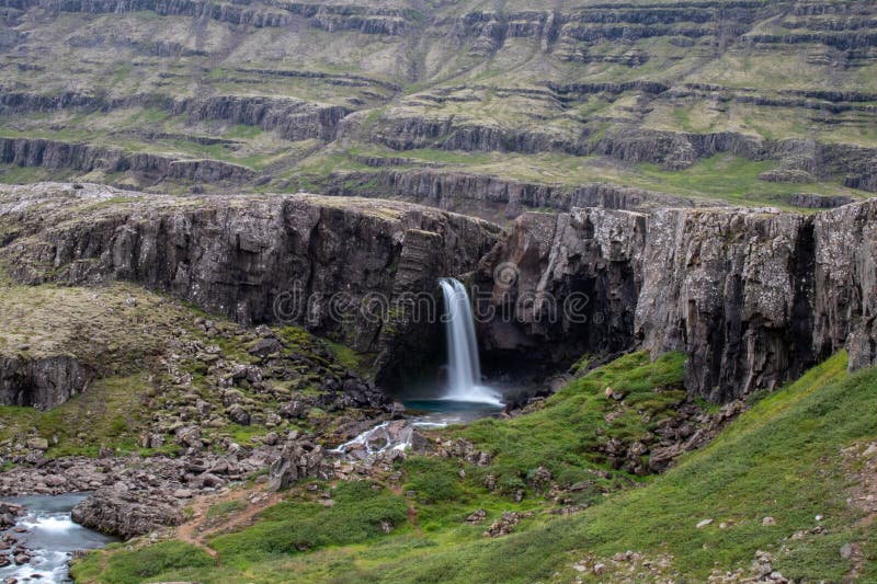 Scenic View of a Distant Waterfall Flowing between Green Cliffs in ...