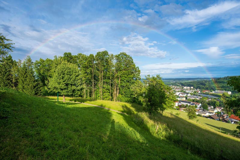 Scenic View of a Lush Green Hillside with a Rainbow Arching Over a ...