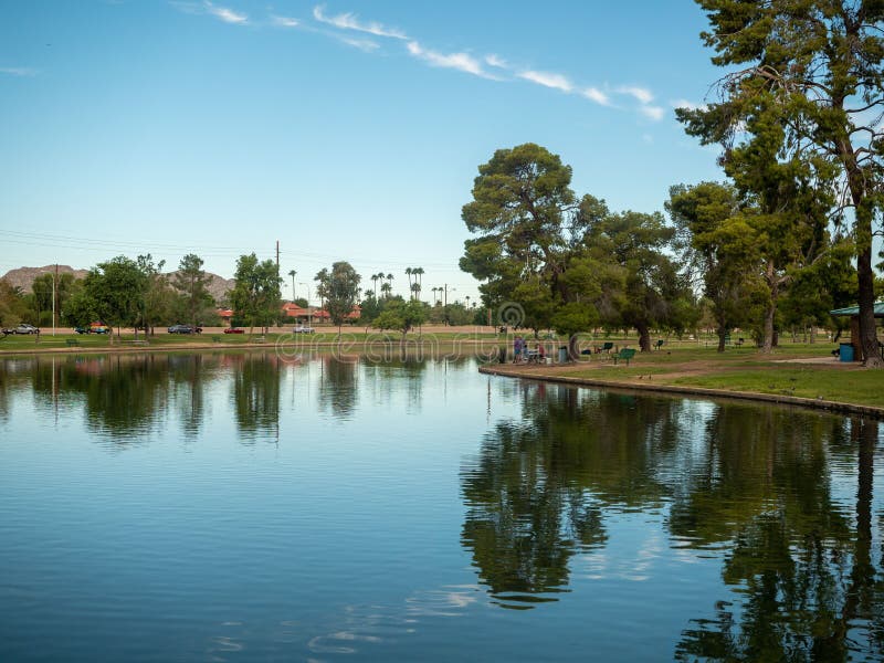 Scenic View of a Reflective Lake with Shorelines Trees Under the Cloudy ...