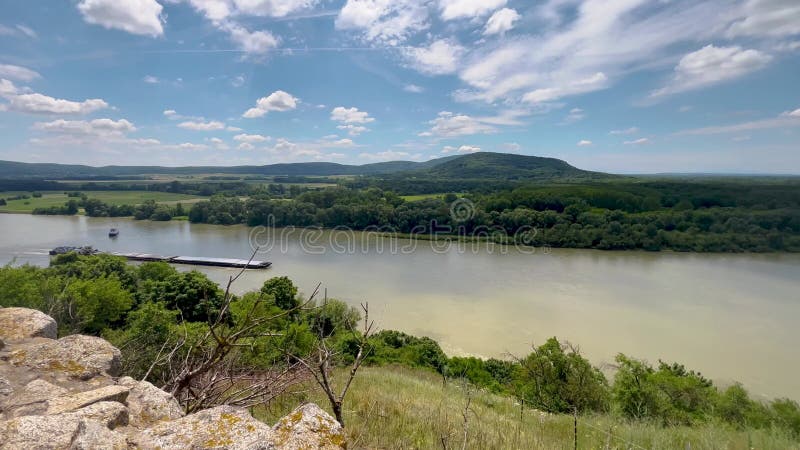 A Scenic View of a Wide River with a Barge Sailing through, Surrounded ...