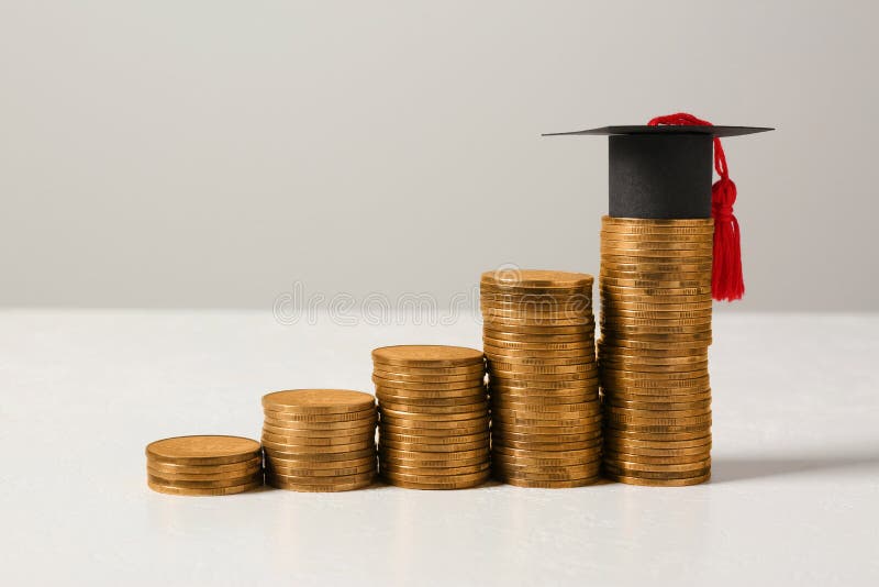 Scholarship Concept. Graduation Cap and Stacked Coins on White Table ...