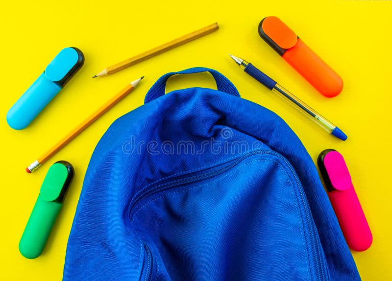School Backpack, Pencils, Markers and a Pen on a Yellow Background ...