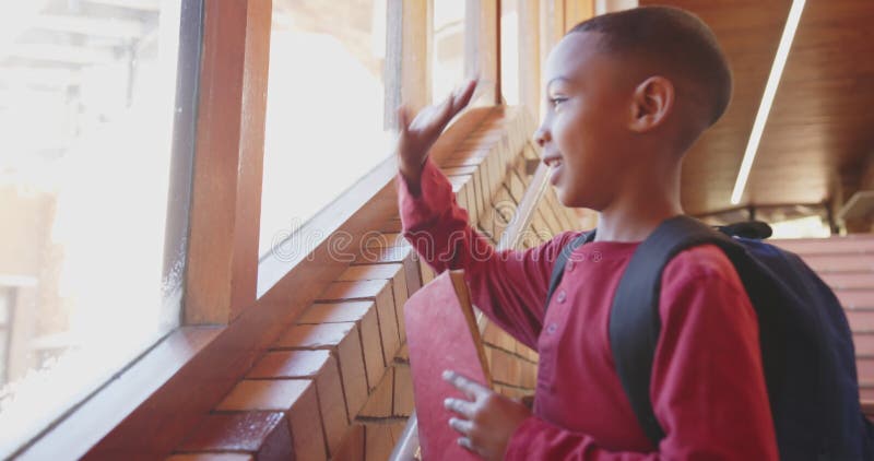 In School, Boy with Backpack Waving at Window, Smiling and Looking ...