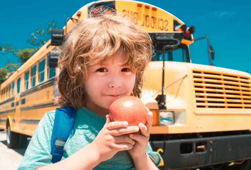 School Boy at the Front of the School Bus Eating Apple. Child from ...