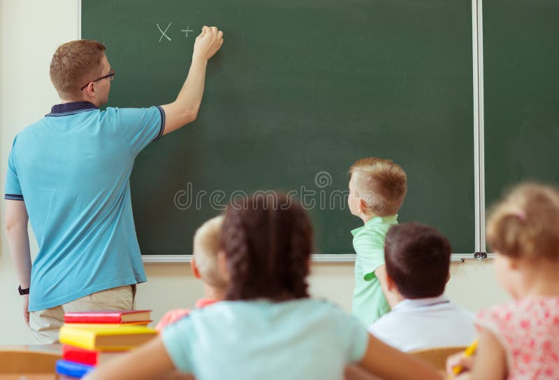 School Boy with His Teacher at the Blackboard at Math Lesson in ...