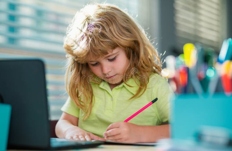 School Boy Making Notes in Copybook during Online Lesson on Laptop at ...