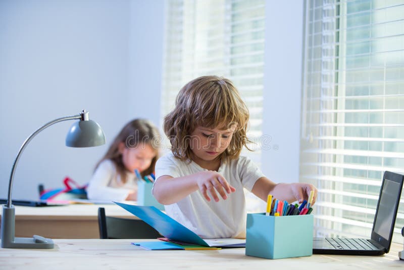 School Boy Sitting at the Table, Writing Homework or Preparing for the ...