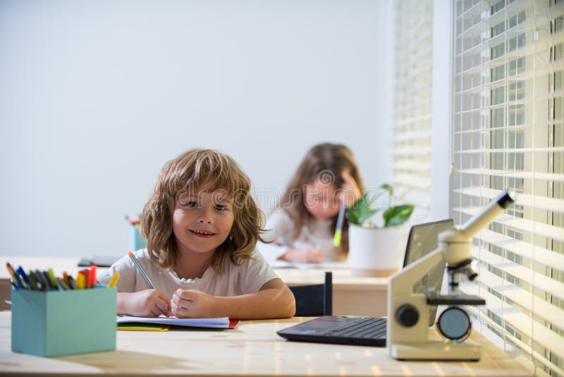 School Boy Sitting at the Table, Writing Homework or Preparing for the ...