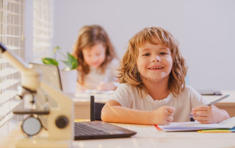 School Boy Sitting at the Table, Writing Homework or Preparing for the ...