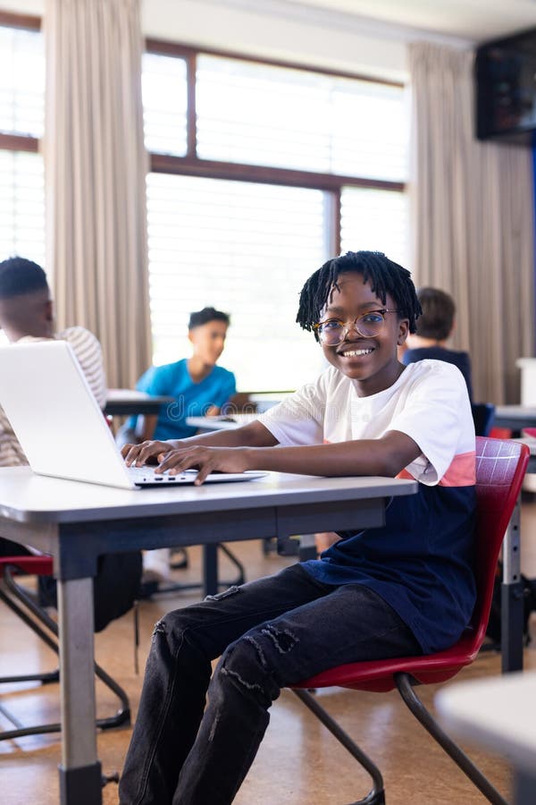 In School, Boy Using Laptop in Classroom, Smiling and Looking at Camera ...
