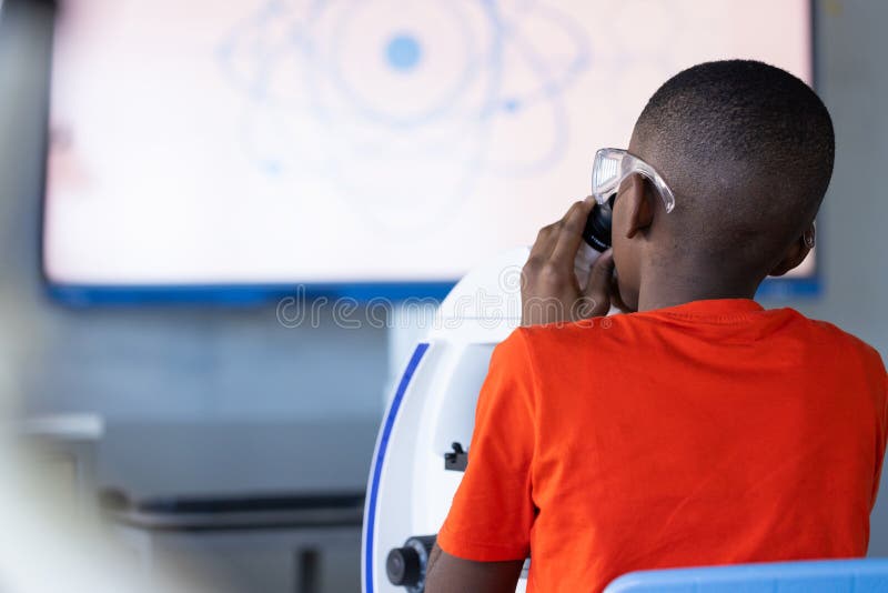 In School, Boy Using Microscope for Science Experiment in Classroom ...