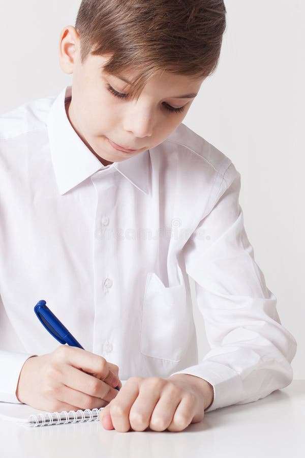 School Boy Writes in Notebook at the Table Stock Image - Image of face ...