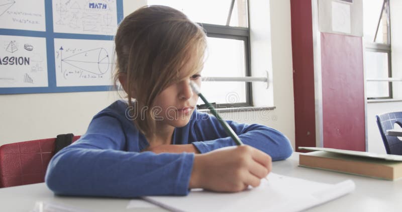 In School, Boy Writing in Notebook at Desk, Concentrating on Homework ...
