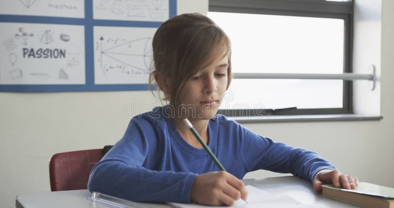 In School, Boy Writing with Pencil in Classroom, Concentrating on Work ...