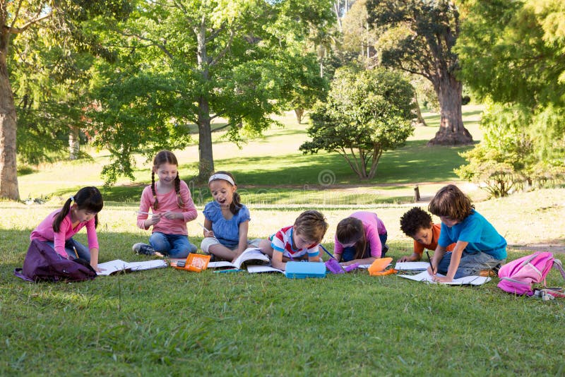 School Children Doing Homework on Grass Stock Photo - Image of ...