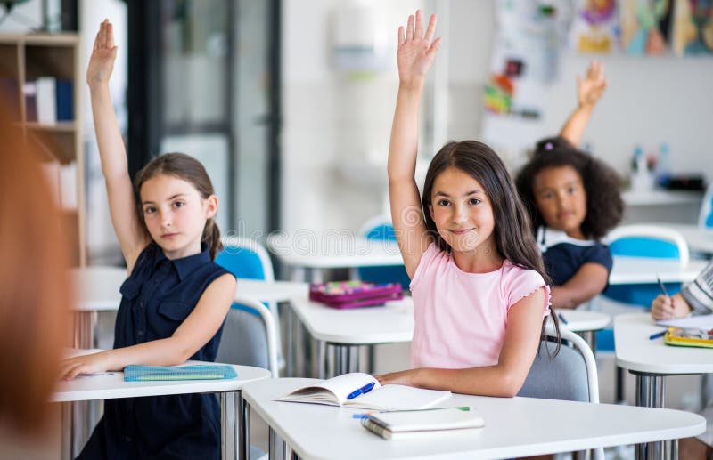 School Children Sitting at the Desk in Classroom on the Lesson, Raising ...