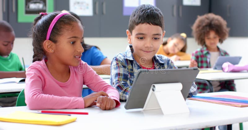 In School, Children Using Tablet and Studying Together in Classroom ...