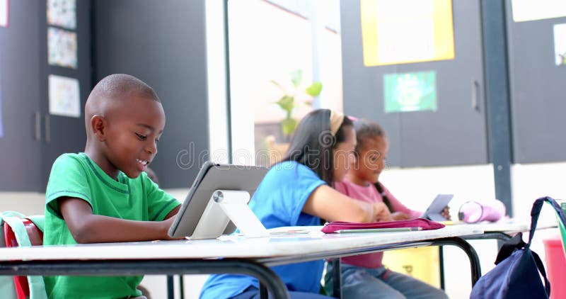 In School, Children Using Tablets and Working Together in Classroom ...