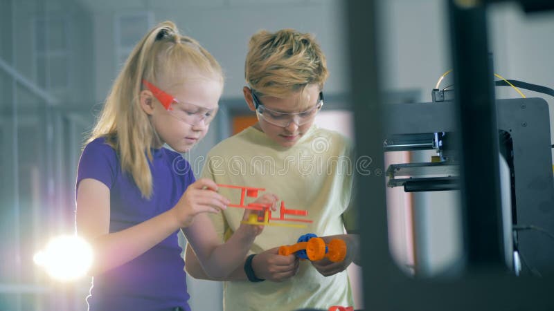 School Children Work with a Printer, Holding 3D Plastic Models. Stock ...