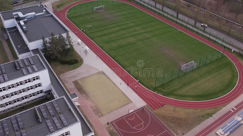 School Complex with Sports Fields and Urban Landscape - Aerial View ...