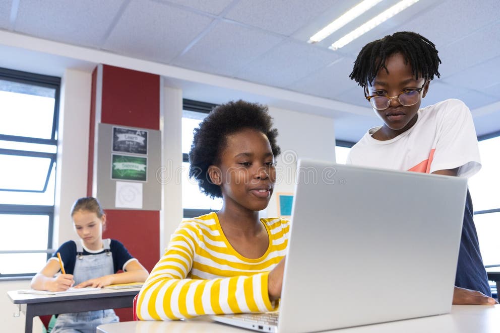In School, Diverse Students Collaborating on Laptop while Classmate ...